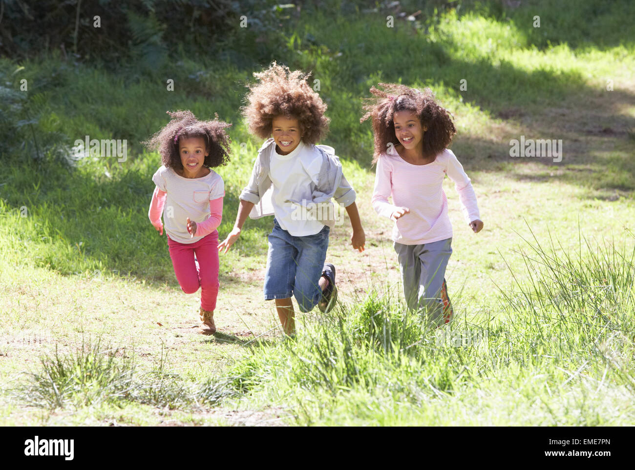 Three Children Playing In Woods Together Stock Photo - Alamy