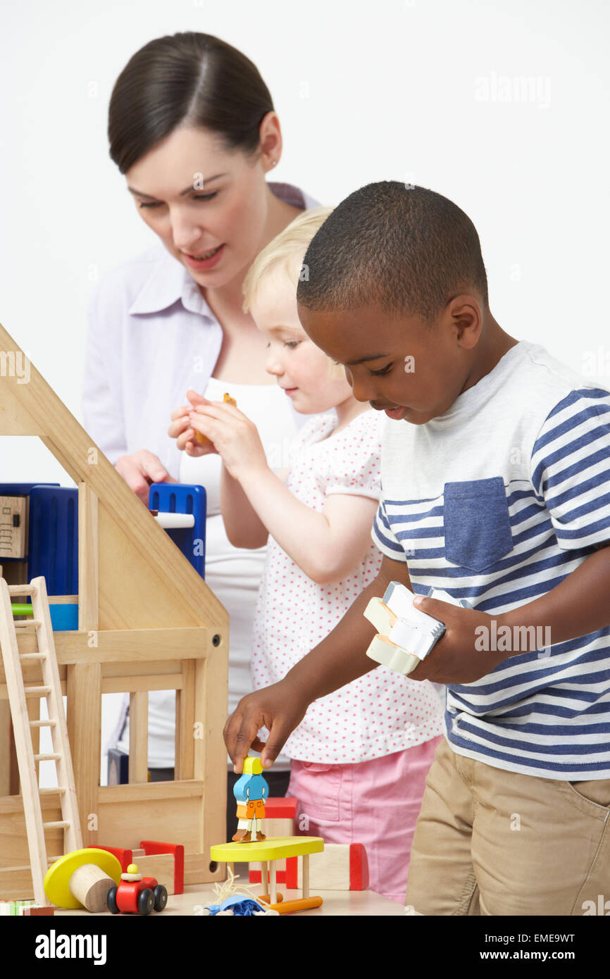 Pre-School Teacher And Pupils Playing With Wooden House Stock Photo - Alamy