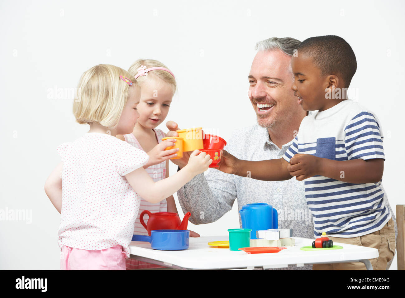 Pre School Children Enjoying Tea Party With Teacher Stock Photo - Alamy