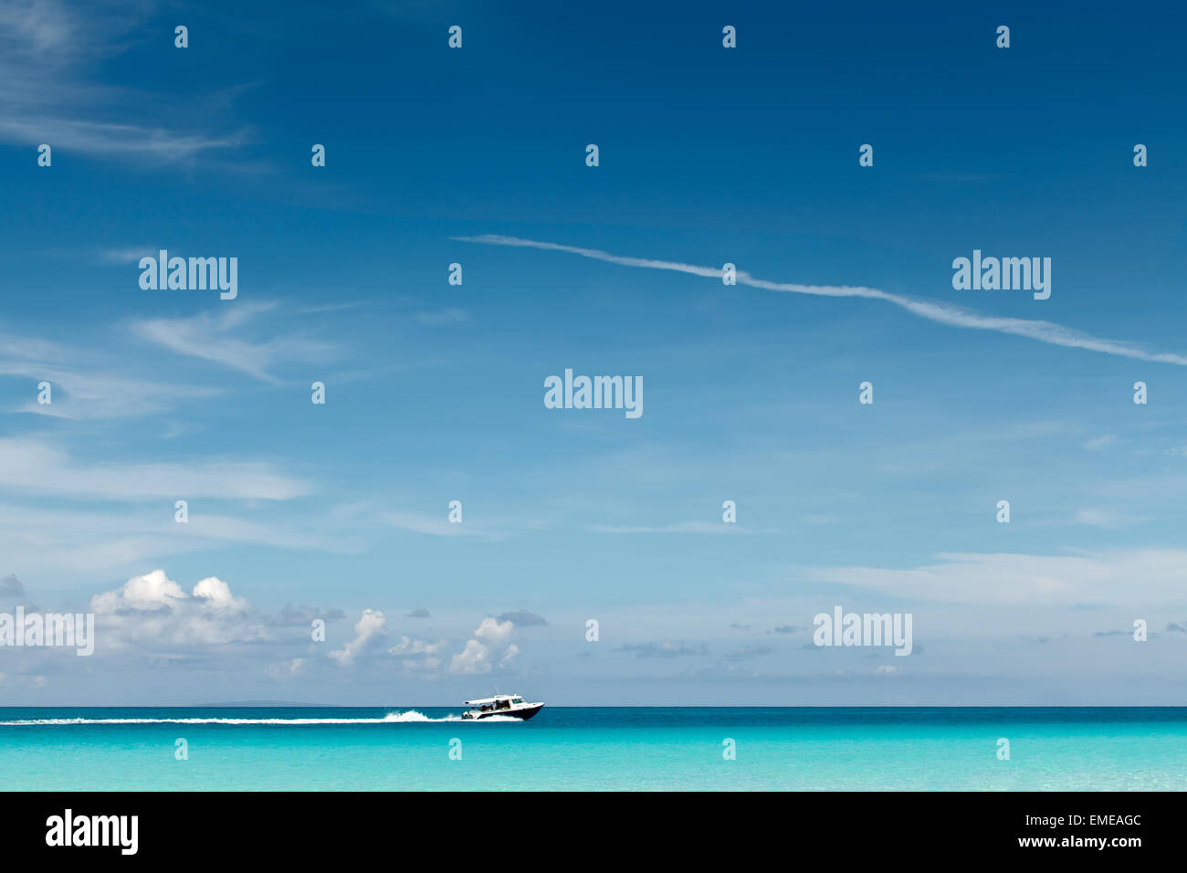 Nice white speedboat on horizon on deep blue see and white clouds on ...