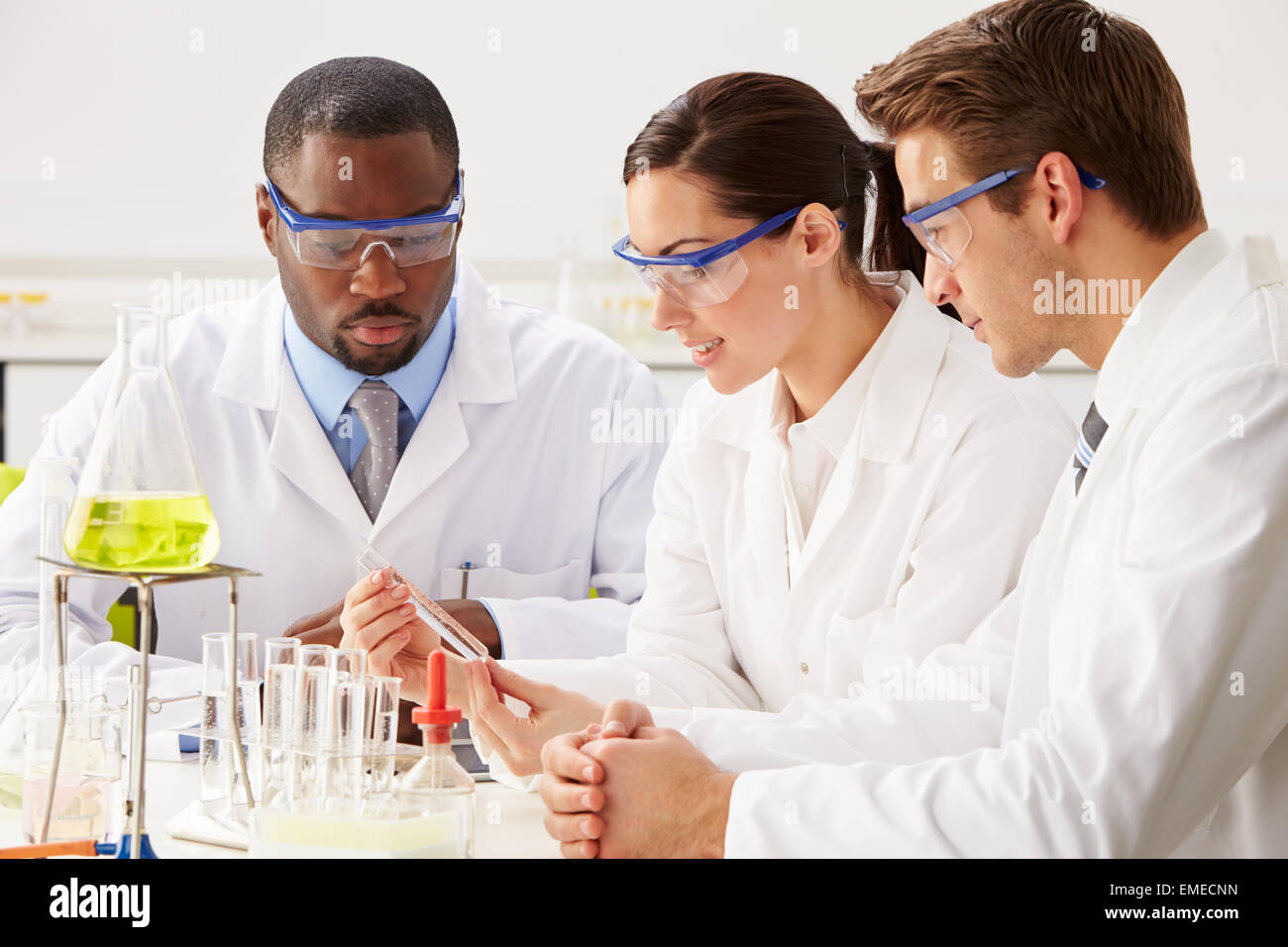Group Of Scientists Performing Experiment In Laboratory Stock Photo - Alamy