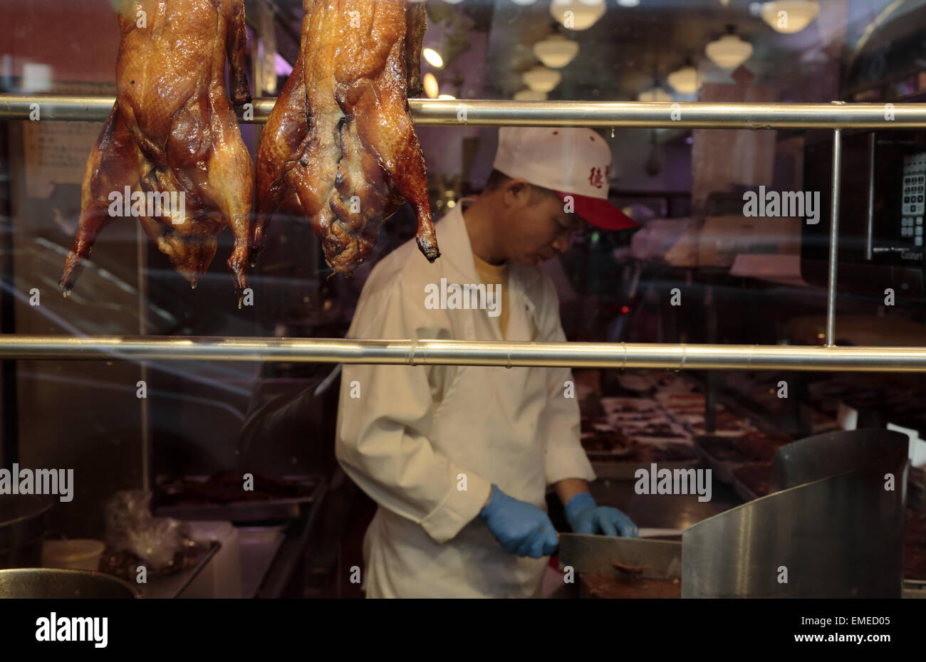 Man preparing food inside a window of a Chinese restaurant in Manhattan ...