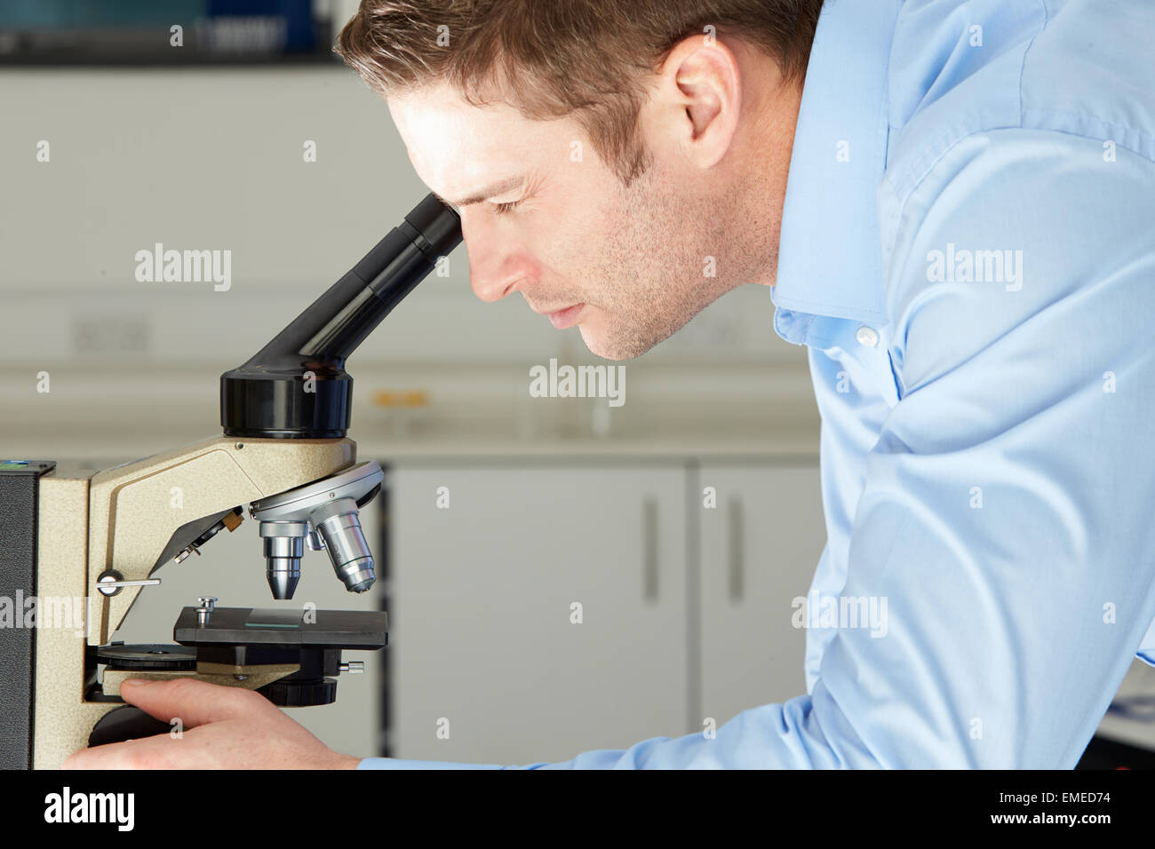 Scientist Looking Through Microscope In Laboratory Stock Photo - Alamy