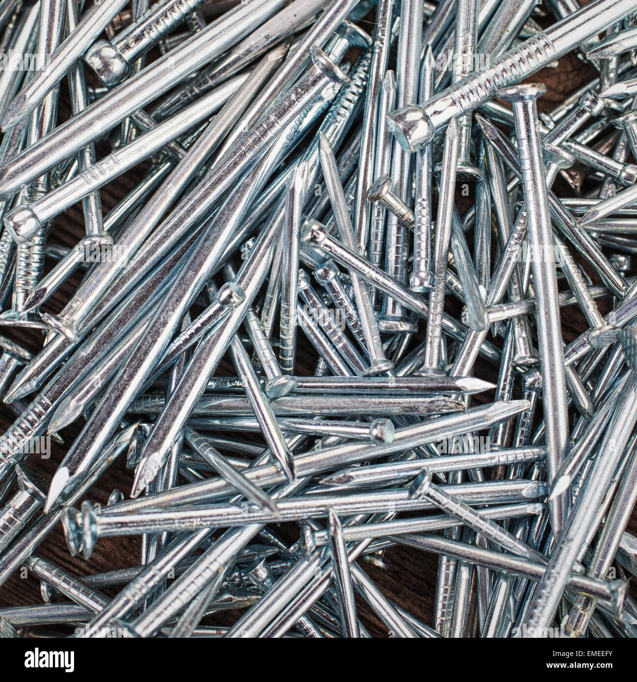 iron nails on wooden background Stock Photo - Alamy