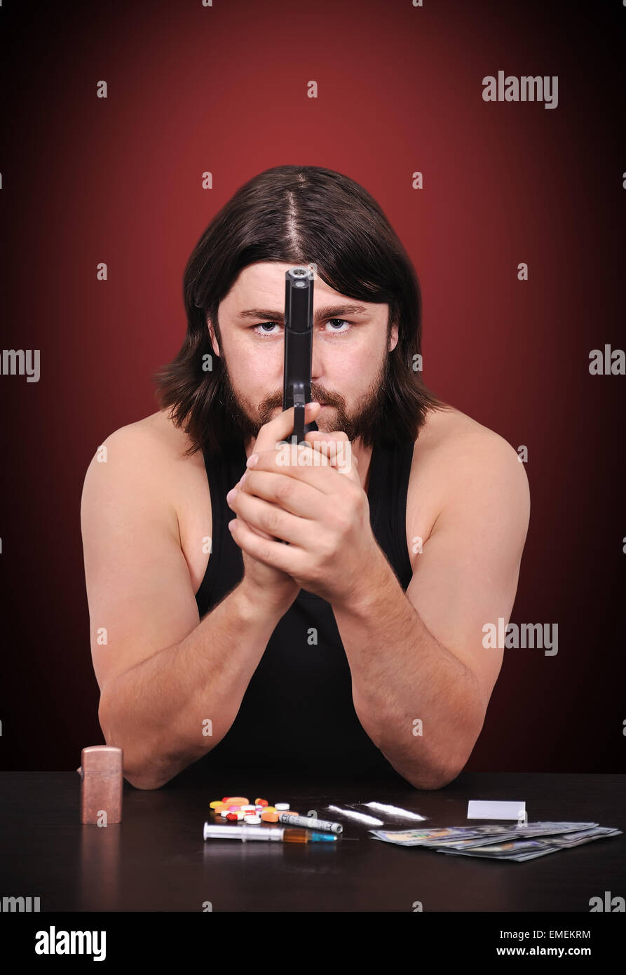 drug dealer with a gun on red background Stock Photo - Alamy