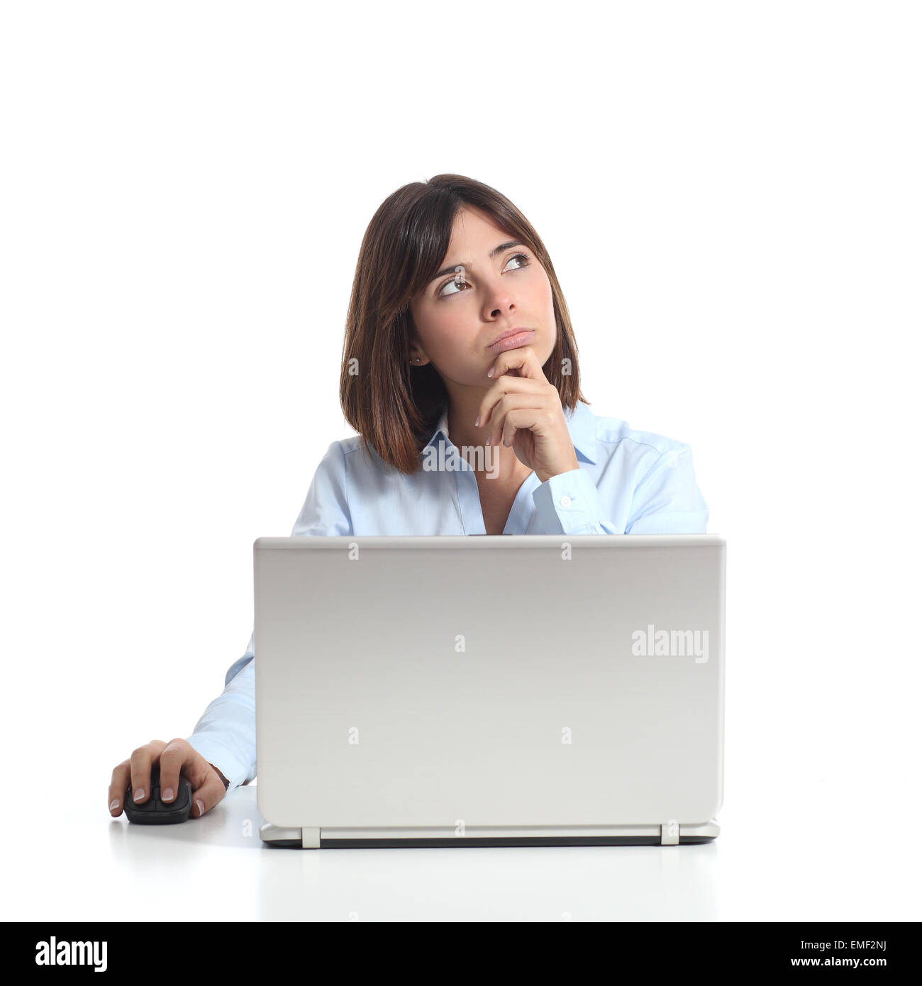 Pensive woman thinking while is using a laptop and looking sideways ...