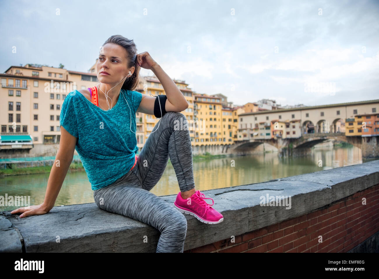 Fitness woman sitting near ponte vecchio in florence, italy Stock Photo ...