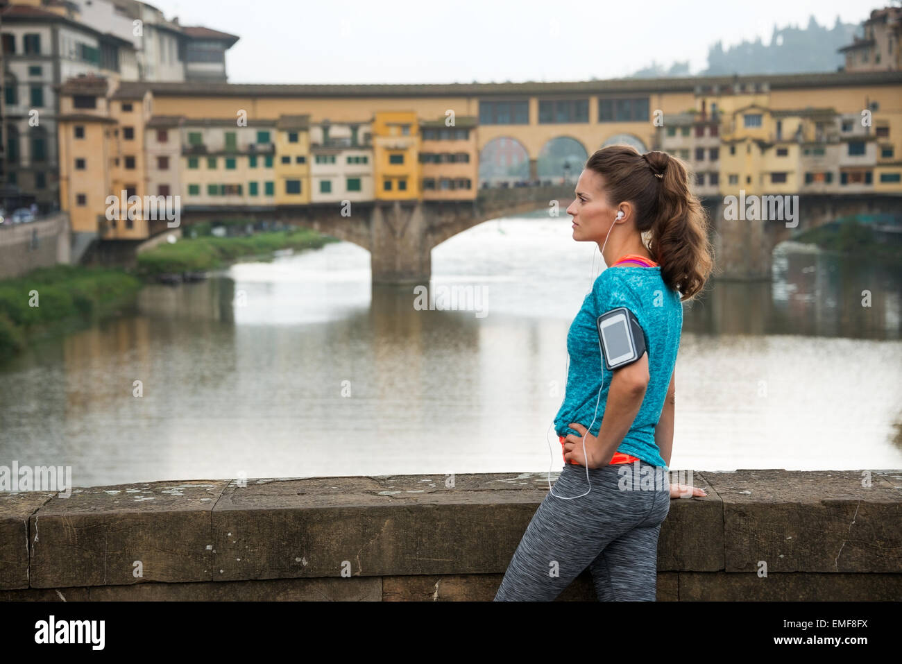 Fitness woman standing in front of ponte vecchio in florence, italy ...