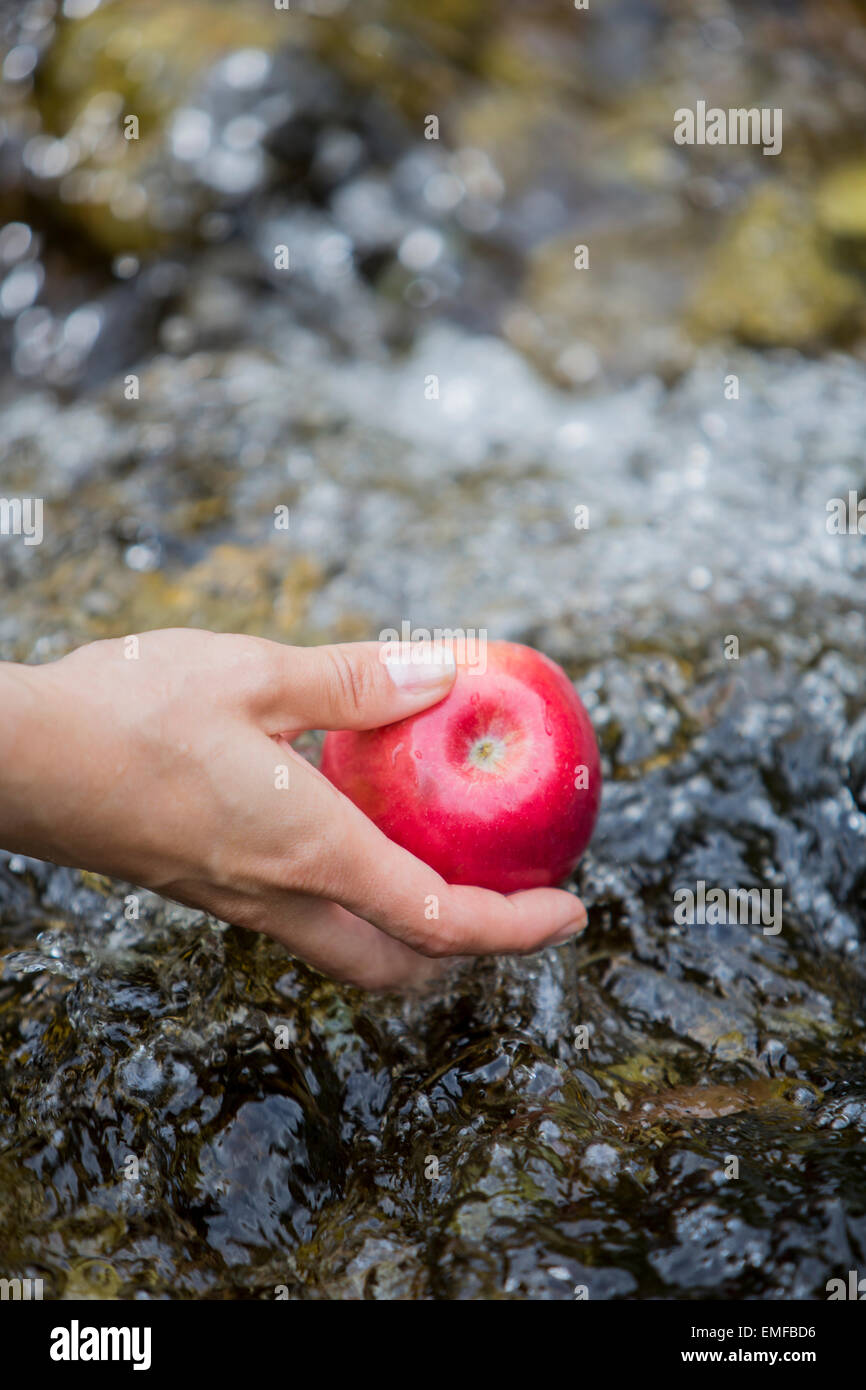 Washing an apple in the clear mountain stream Stock Photo - Alamy