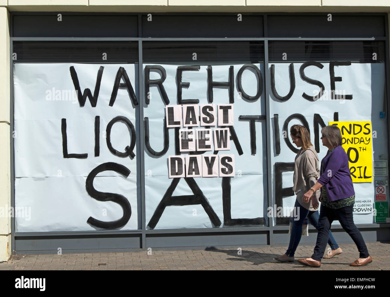 two women walk past shop window sales signs, kingston upon thames ...