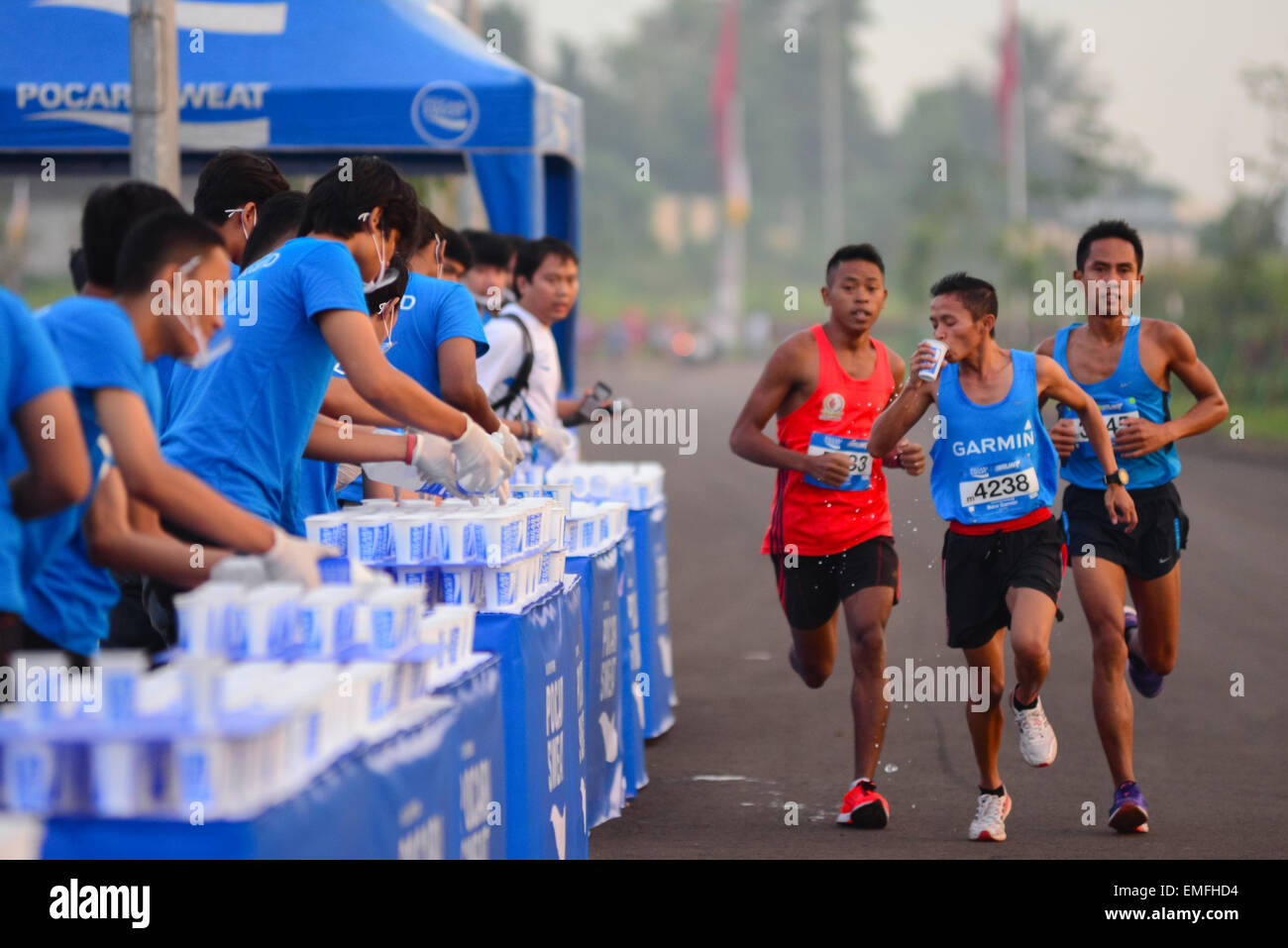 Runners drink at refreshment station while running at Pocari Sweat ...