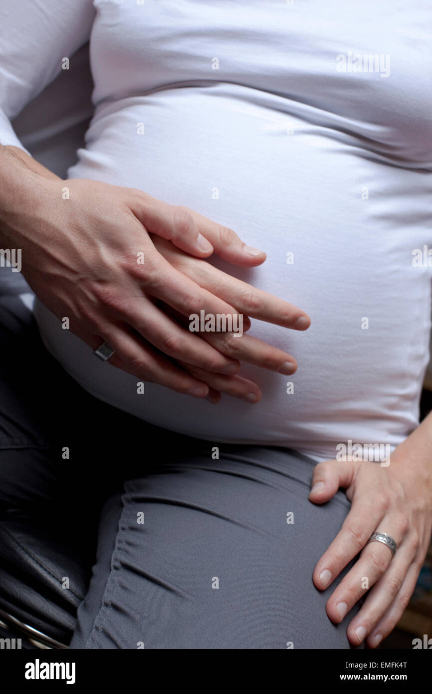 Hands on the belly of a pregnant woman Stock Photo - Alamy