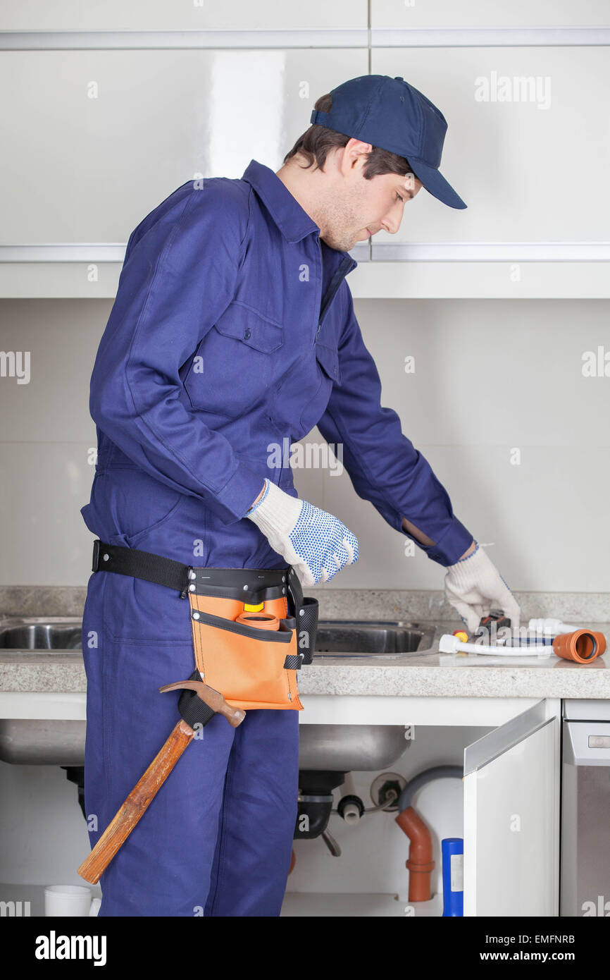 Plumber fixing the kitchen Stock Photo - Alamy