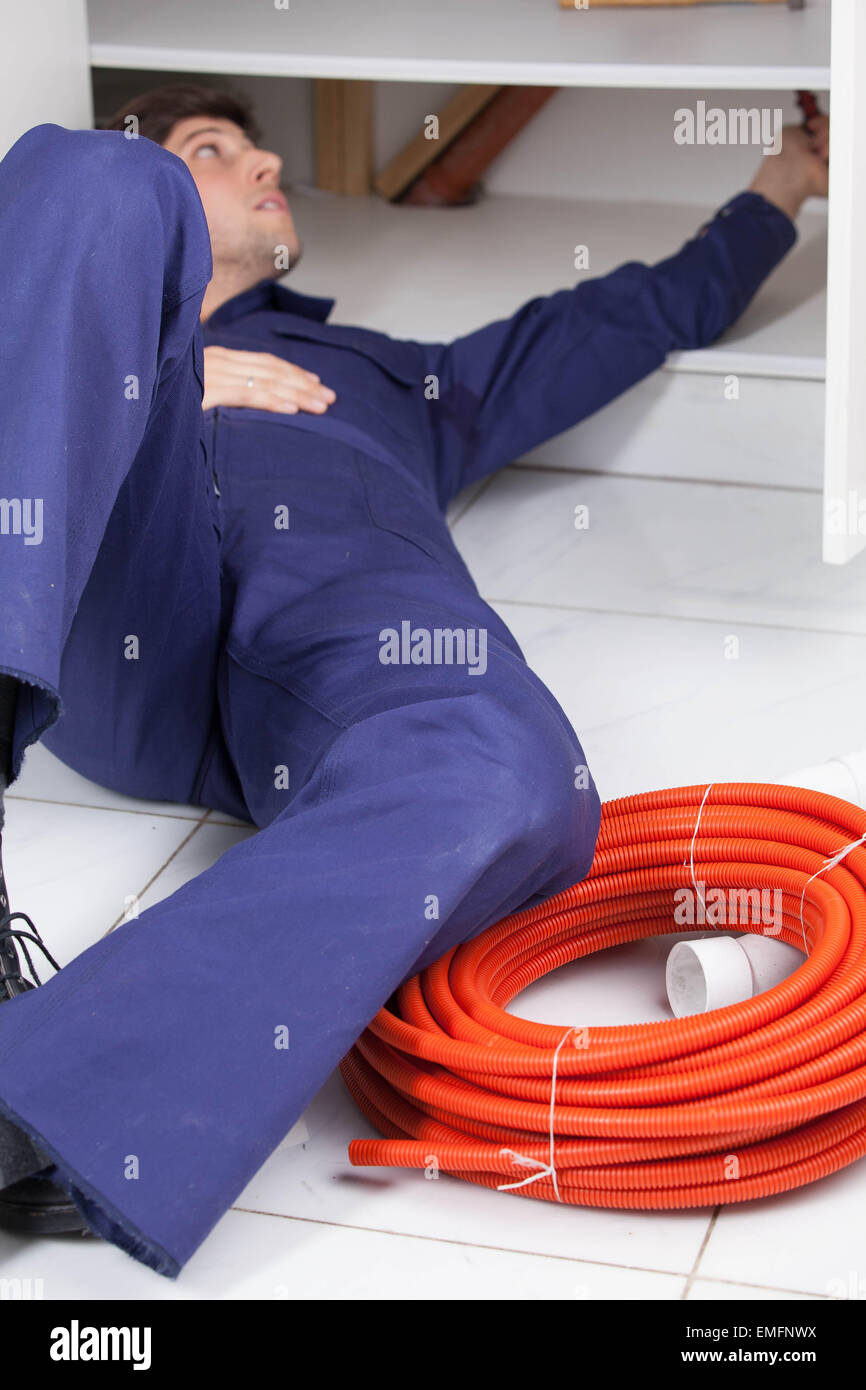 Plumber fixing the kitchen Stock Photo - Alamy