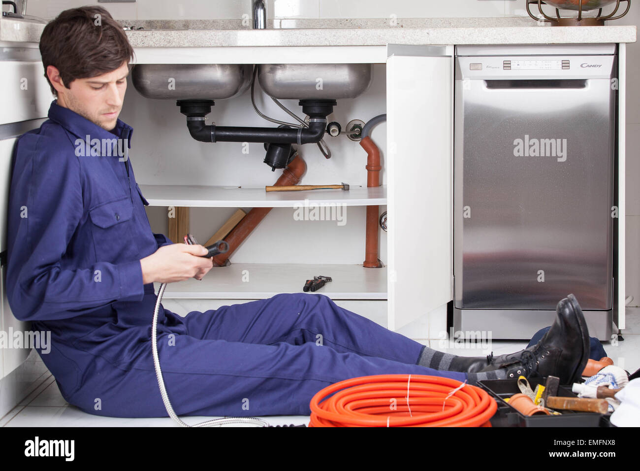 Plumber fixing the kitchen Stock Photo - Alamy