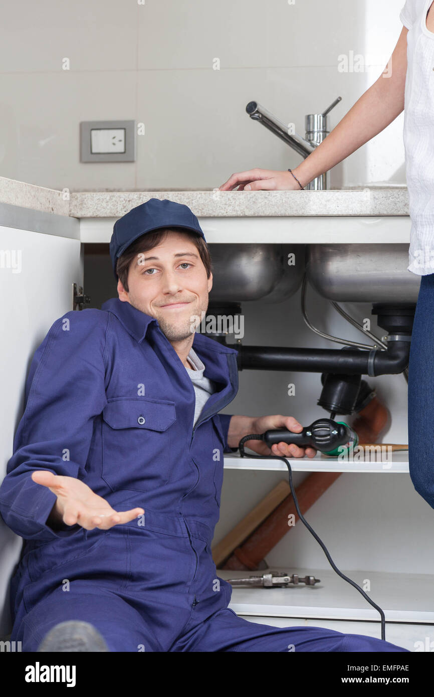 Plumber working on the kitchen Stock Photo - Alamy