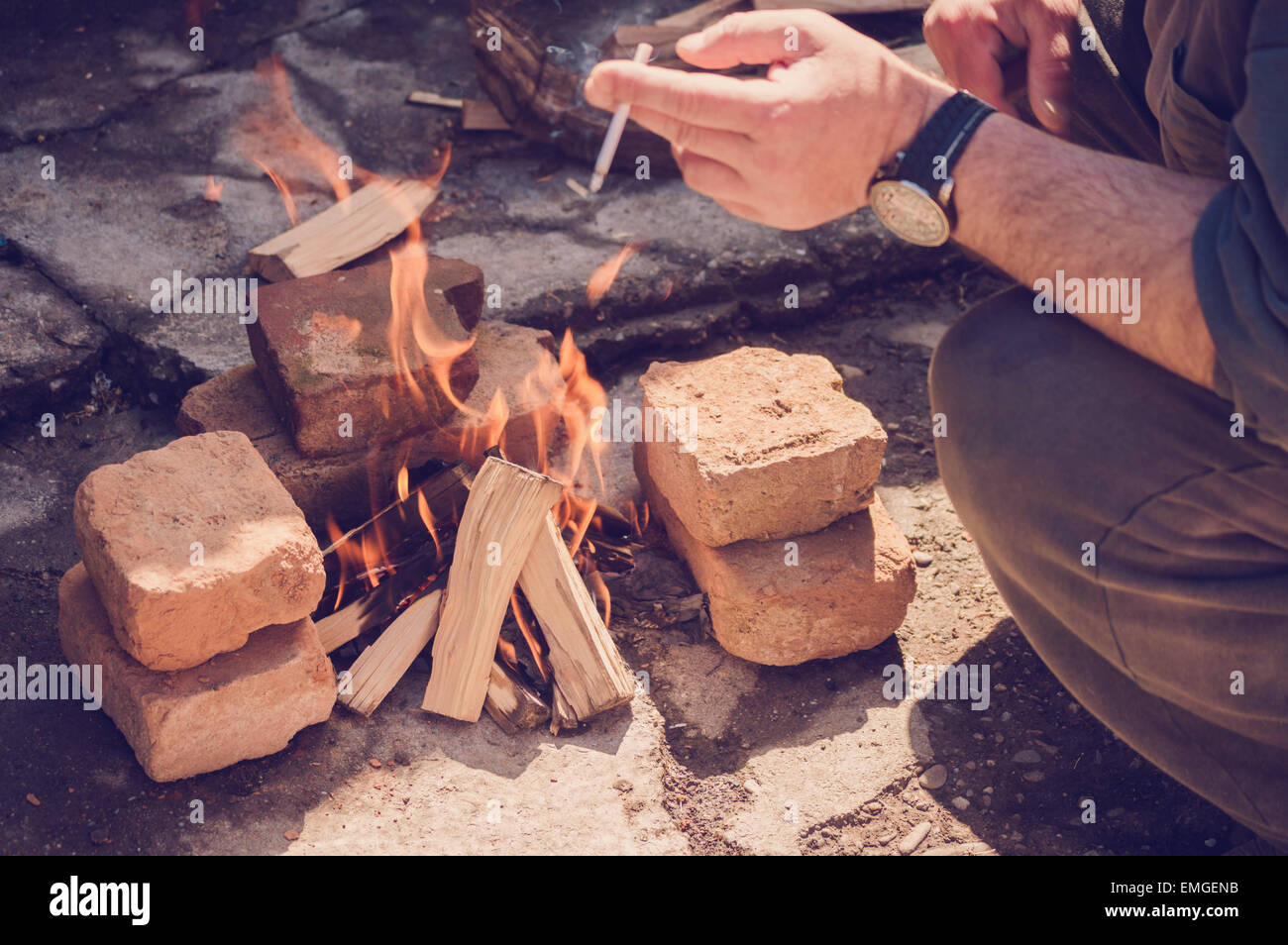Man relaxing near fire, amoking Stock Photo - Alamy