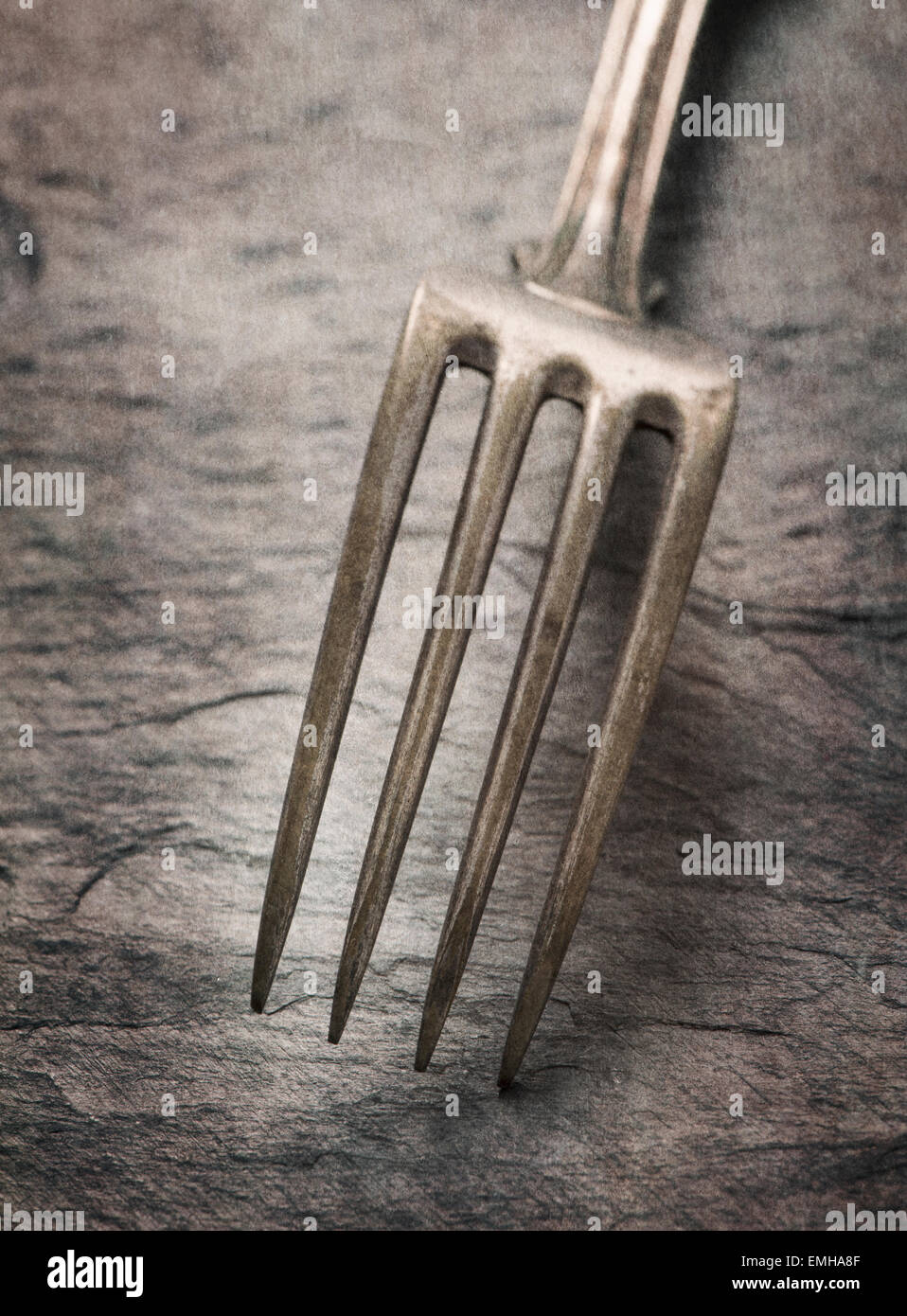 Still life with silver fork on stone surface Stock Photo - Alamy