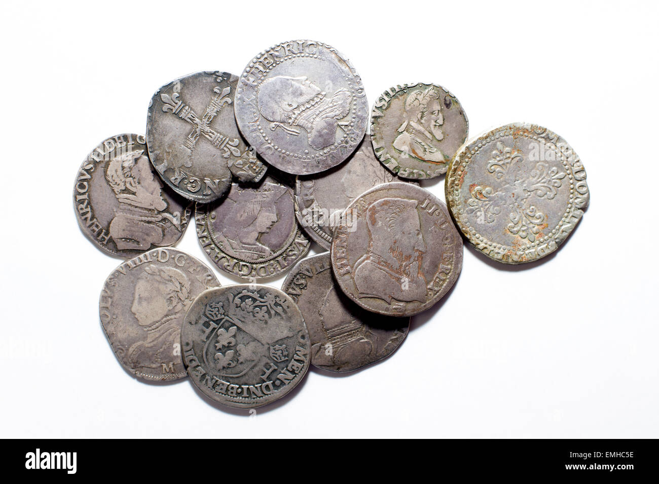 A lot of old silver coins with portraits of kings on a white background ...