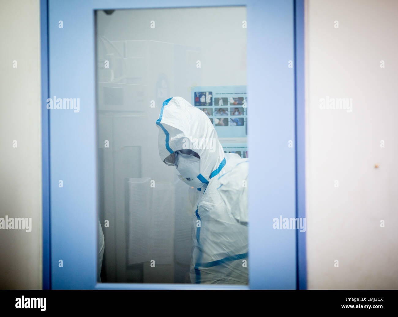 A staff member puts on his protective suit at the Noguchi laboratory of the university in Accra ...