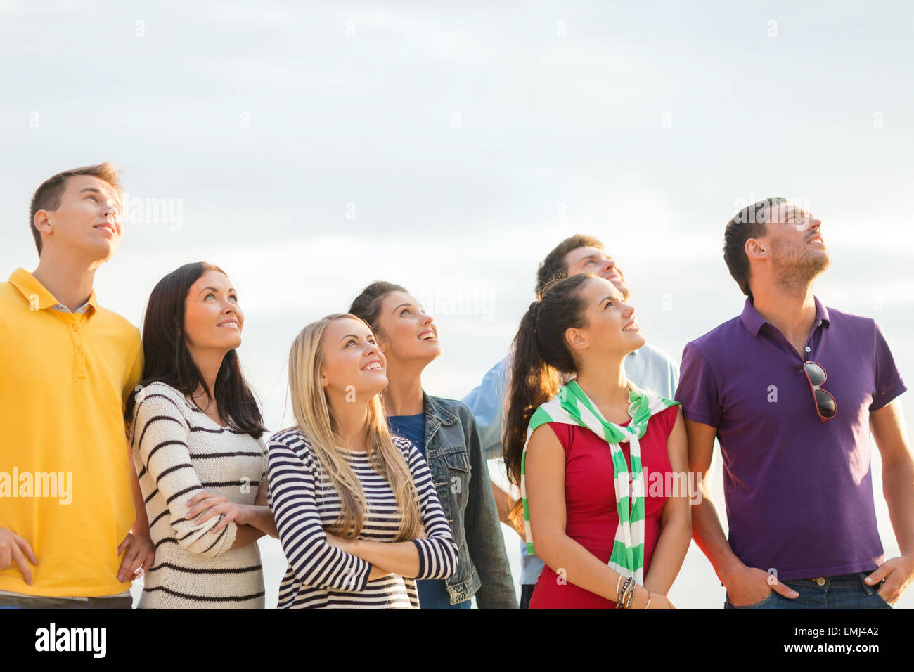 group of happy friends looking up on beach Stock Photo - Alamy