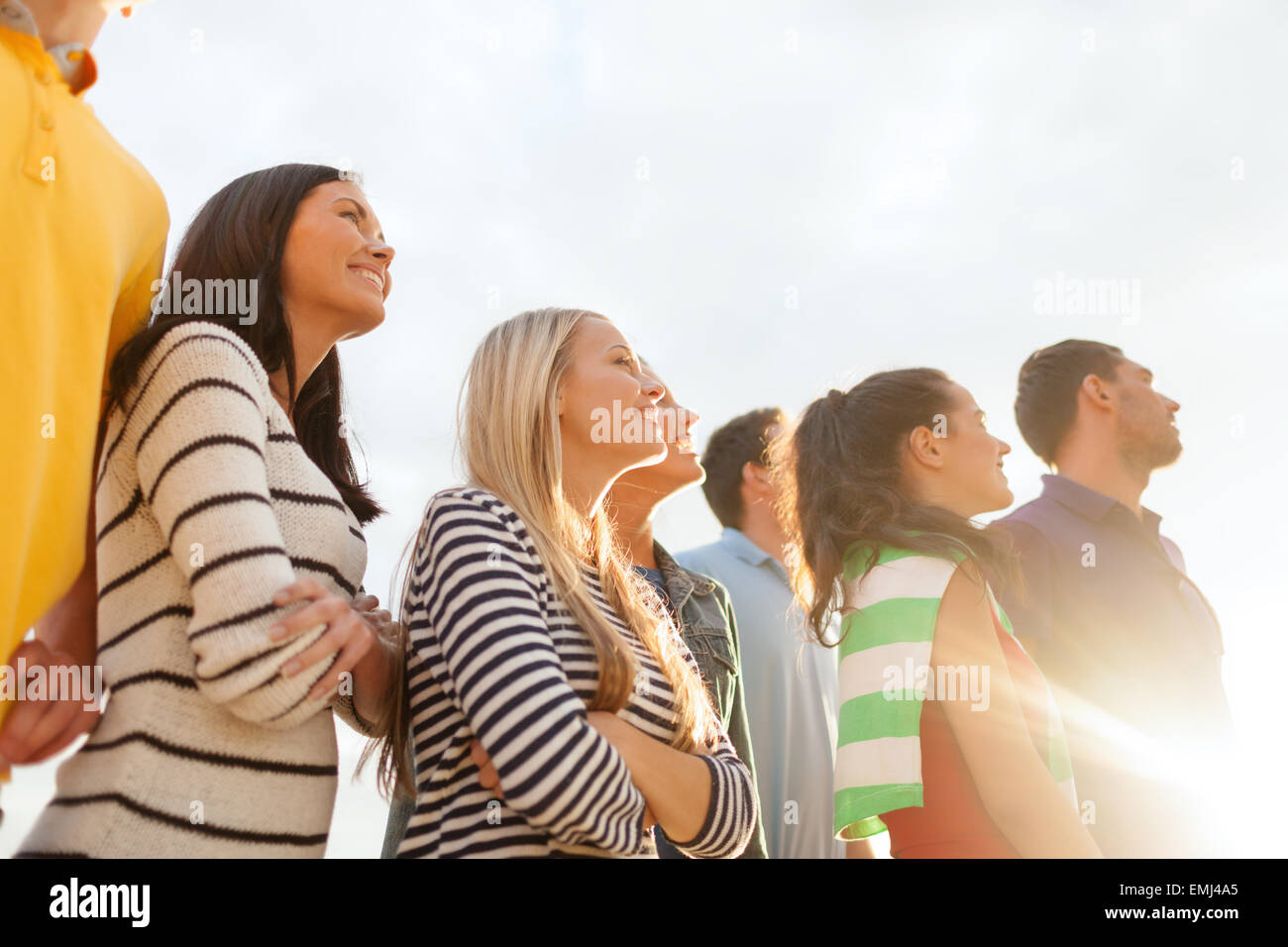 group of happy friends looking up on beach Stock Photo - Alamy