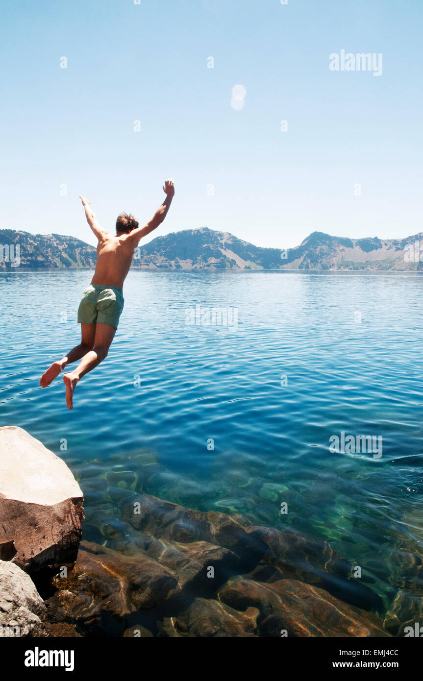 Young Man Jumping into Lake Stock Photo - Alamy