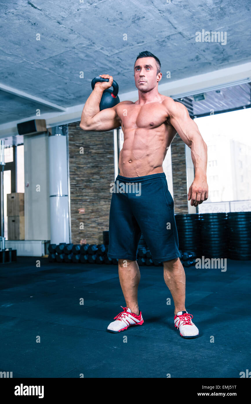 Full length portrait of a handsome bodybuilder workout with kettle ball ...