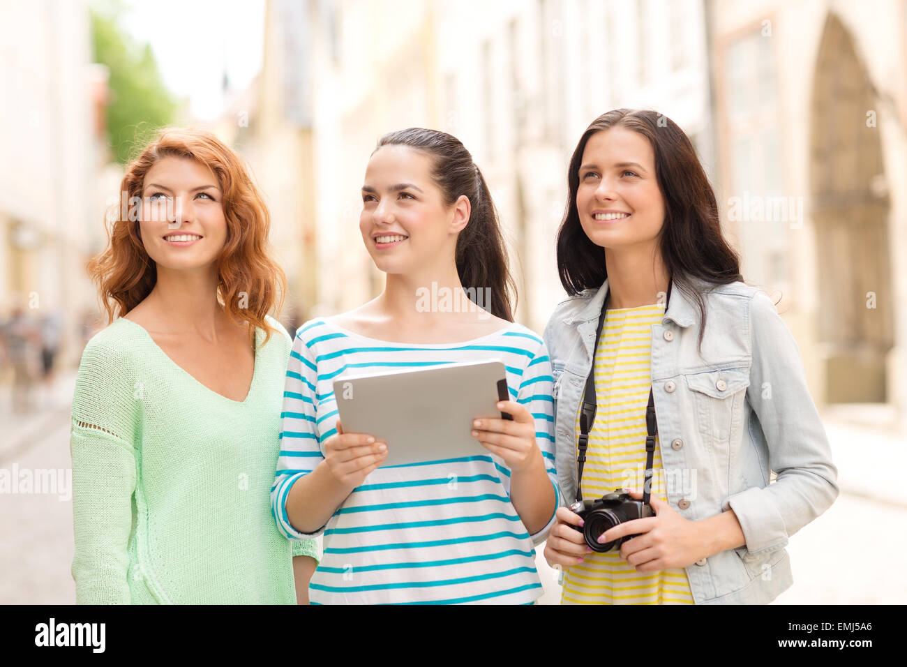 smiling teenage girls with tablet pc and camera Stock Photo - Alamy