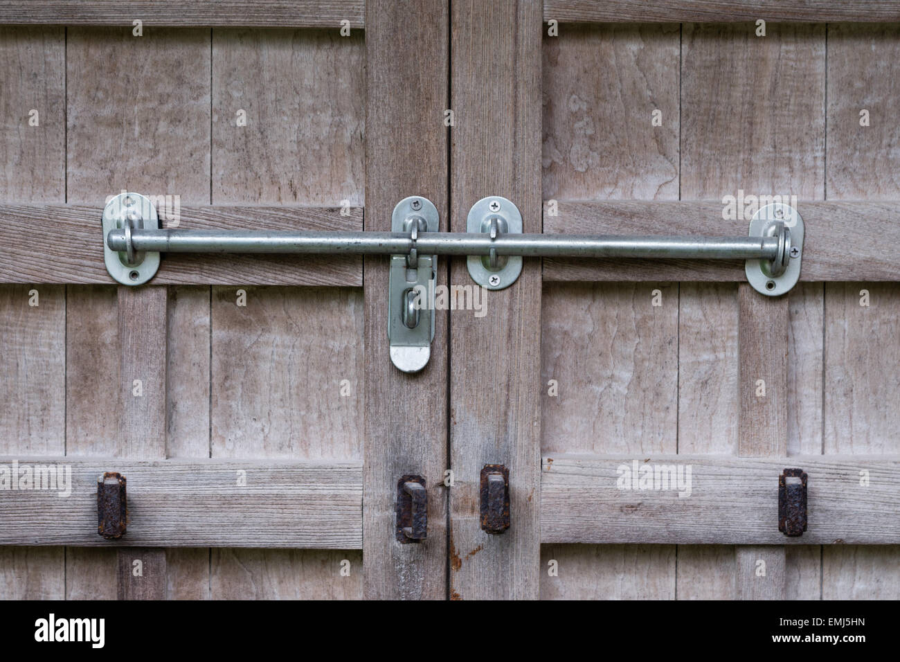 An old wooden door with rusty old locks and newer silver locks Stock ...