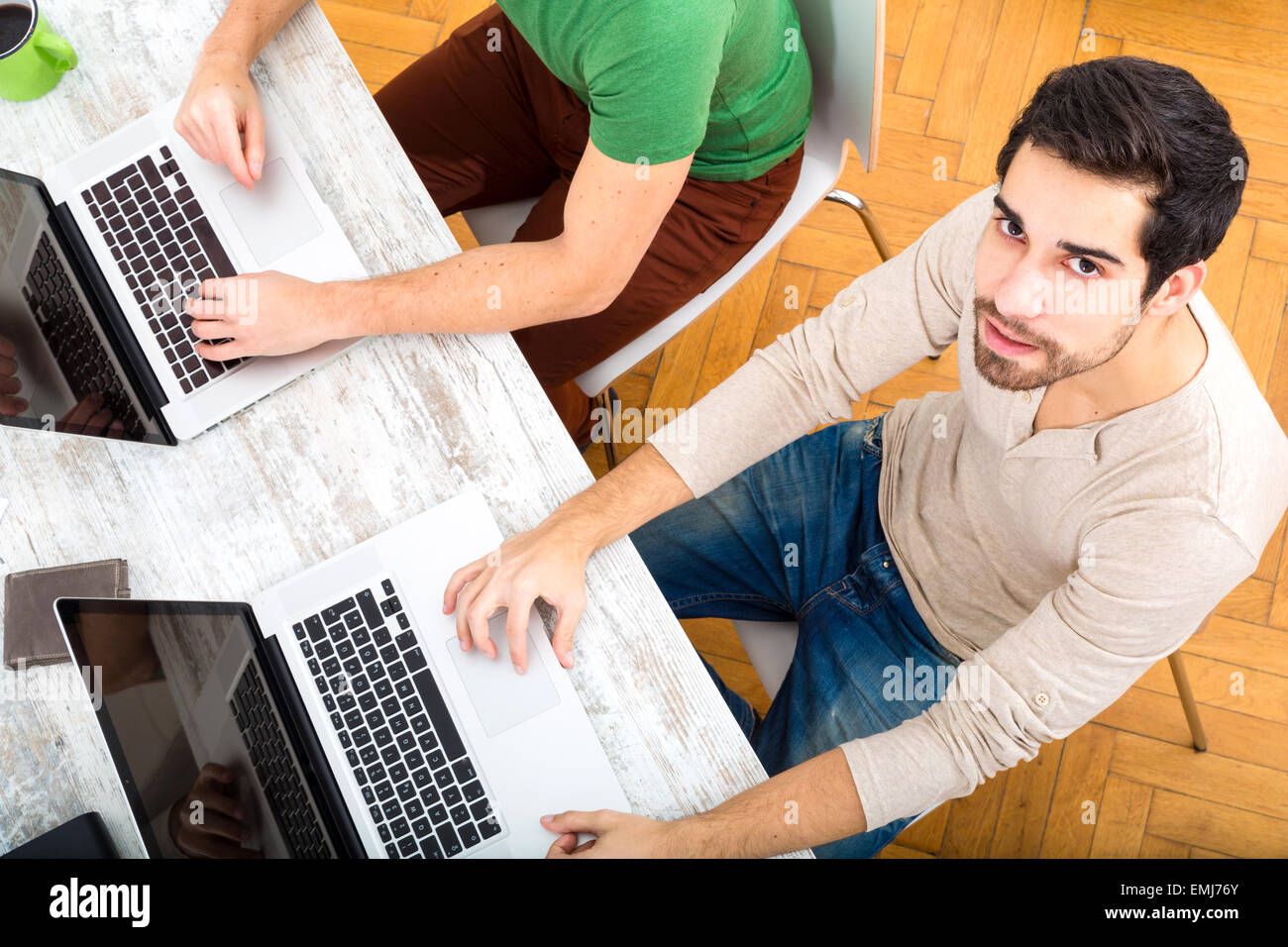 Two workmates teaming up and working together Stock Photo - Alamy