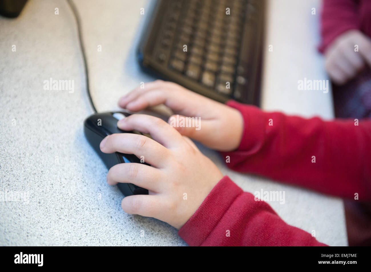 UK schoolboy using a mouse and keyboard in an ICT lesson at school ...