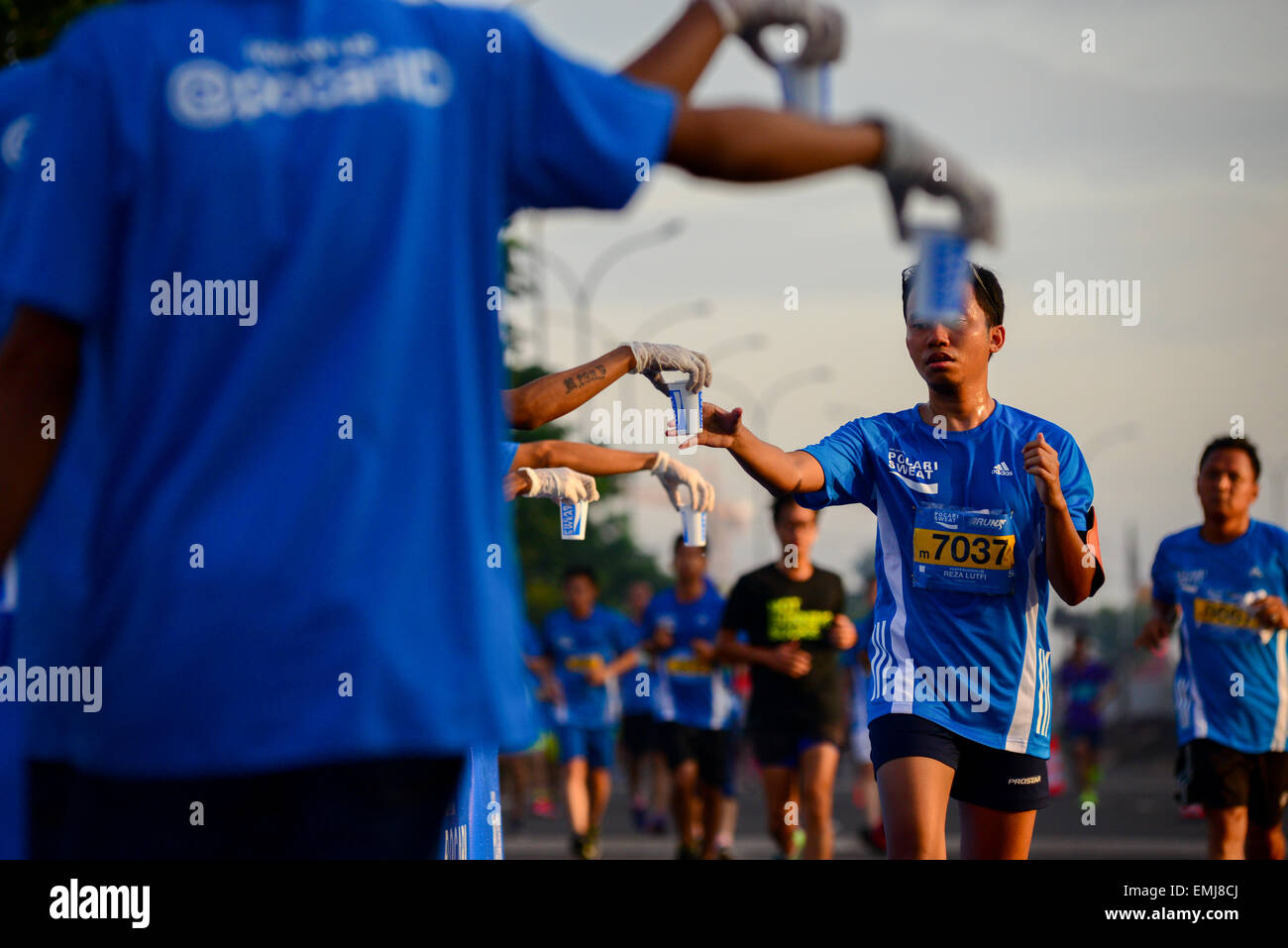 Runners passing a refreshment drink station while running in "Pocari ...