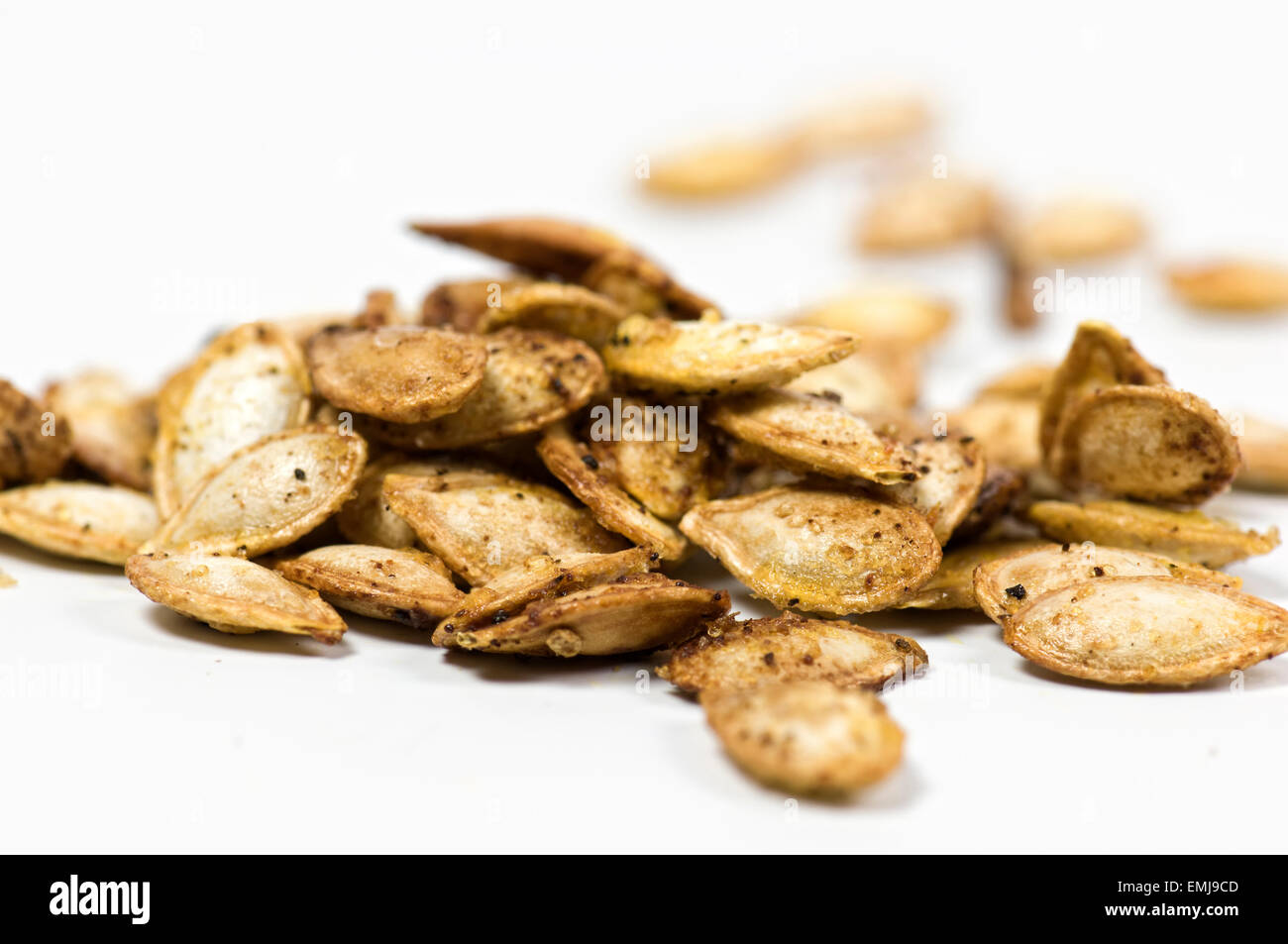 Roasted butternut squash seeds on white background Stock Photo - Alamy