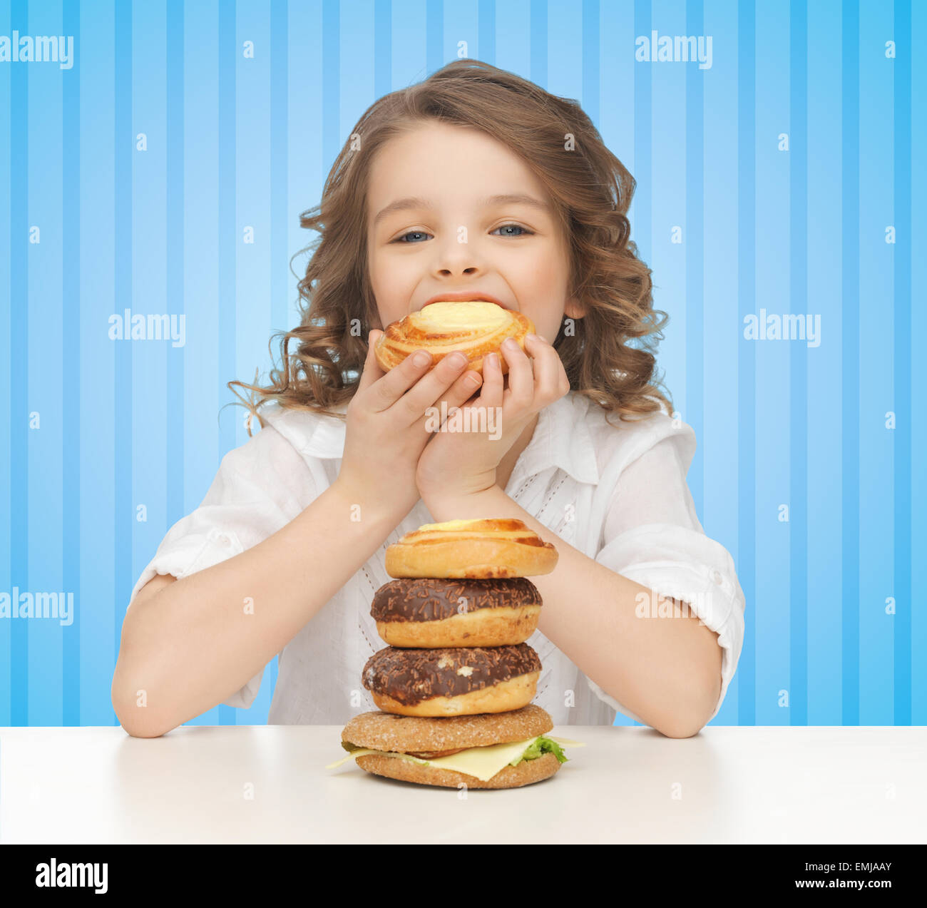 happy little girl eating junk food Stock Photo - Alamy