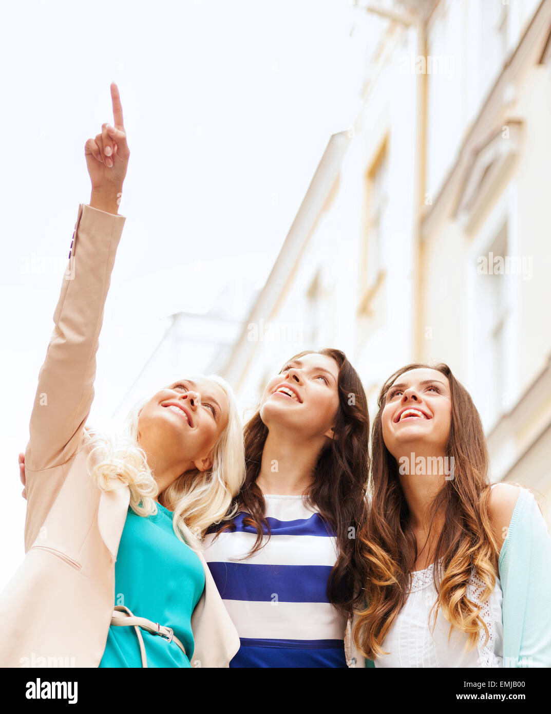 beautiful girls looking at something in the city Stock Photo - Alamy
