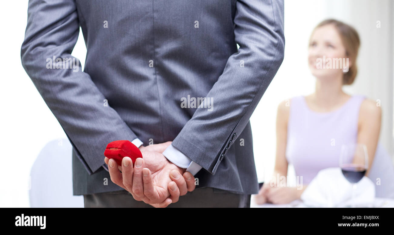 close up of man hiding red box behind from woman Stock Photo - Alamy