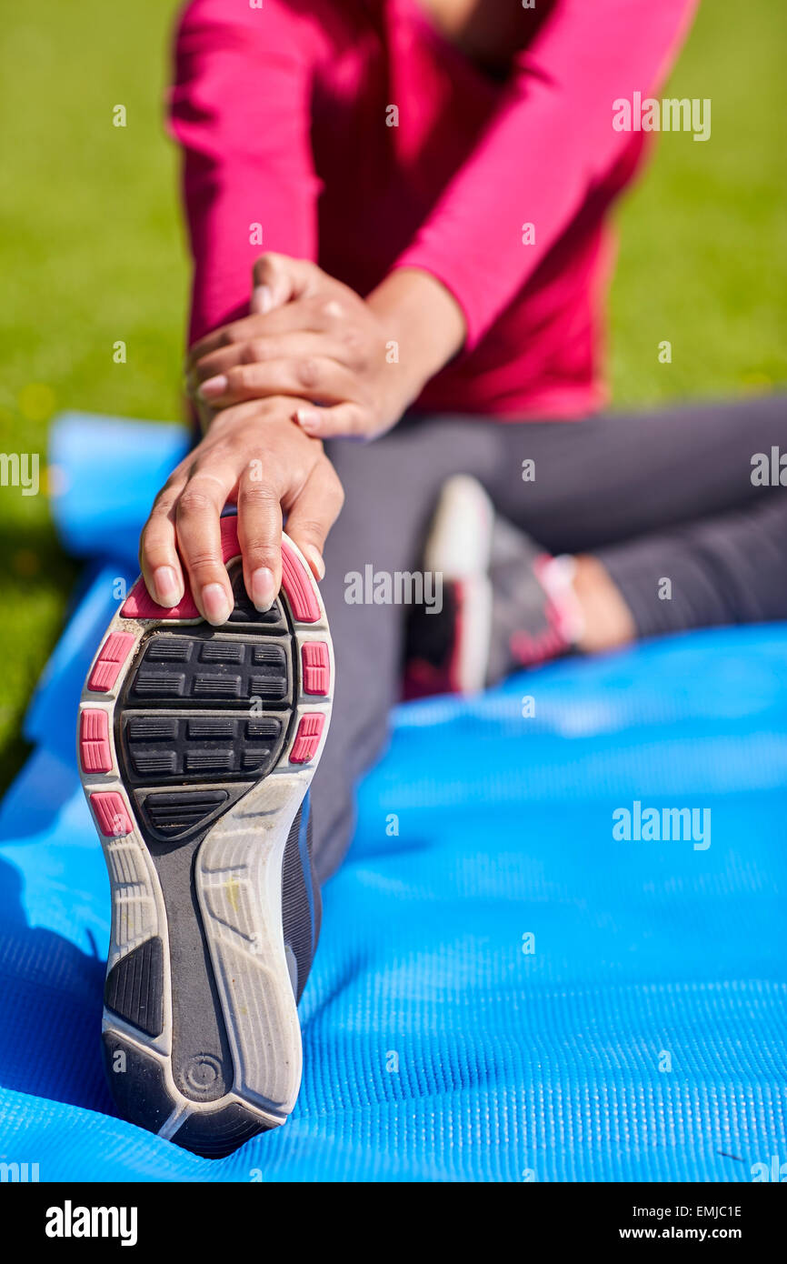 close up of woman stretching leg on mat outdoors Stock Photo - Alamy