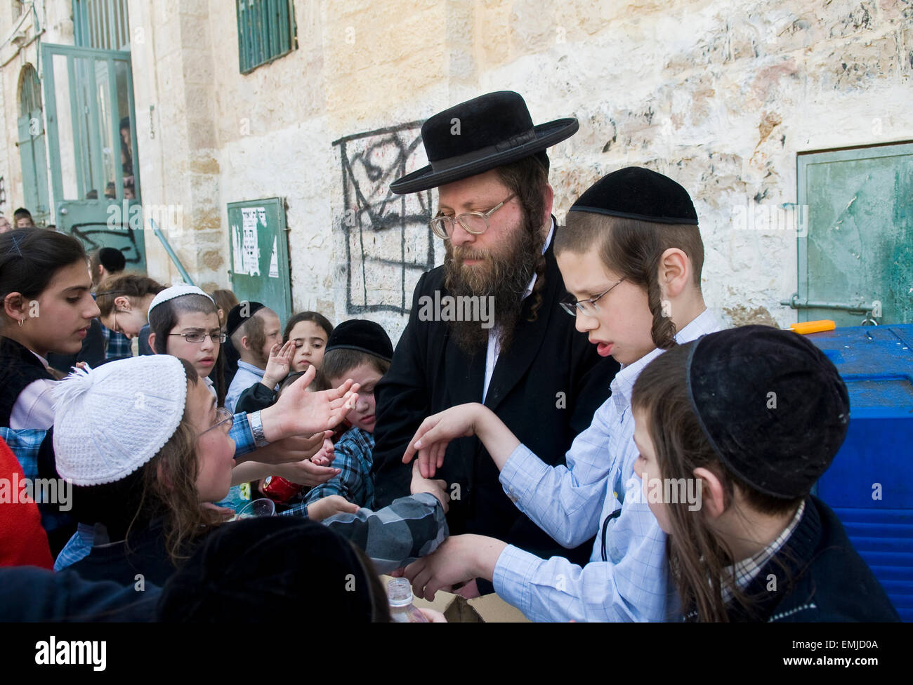 An Ultra Orthodox Jew man handing out food to poor children in ...