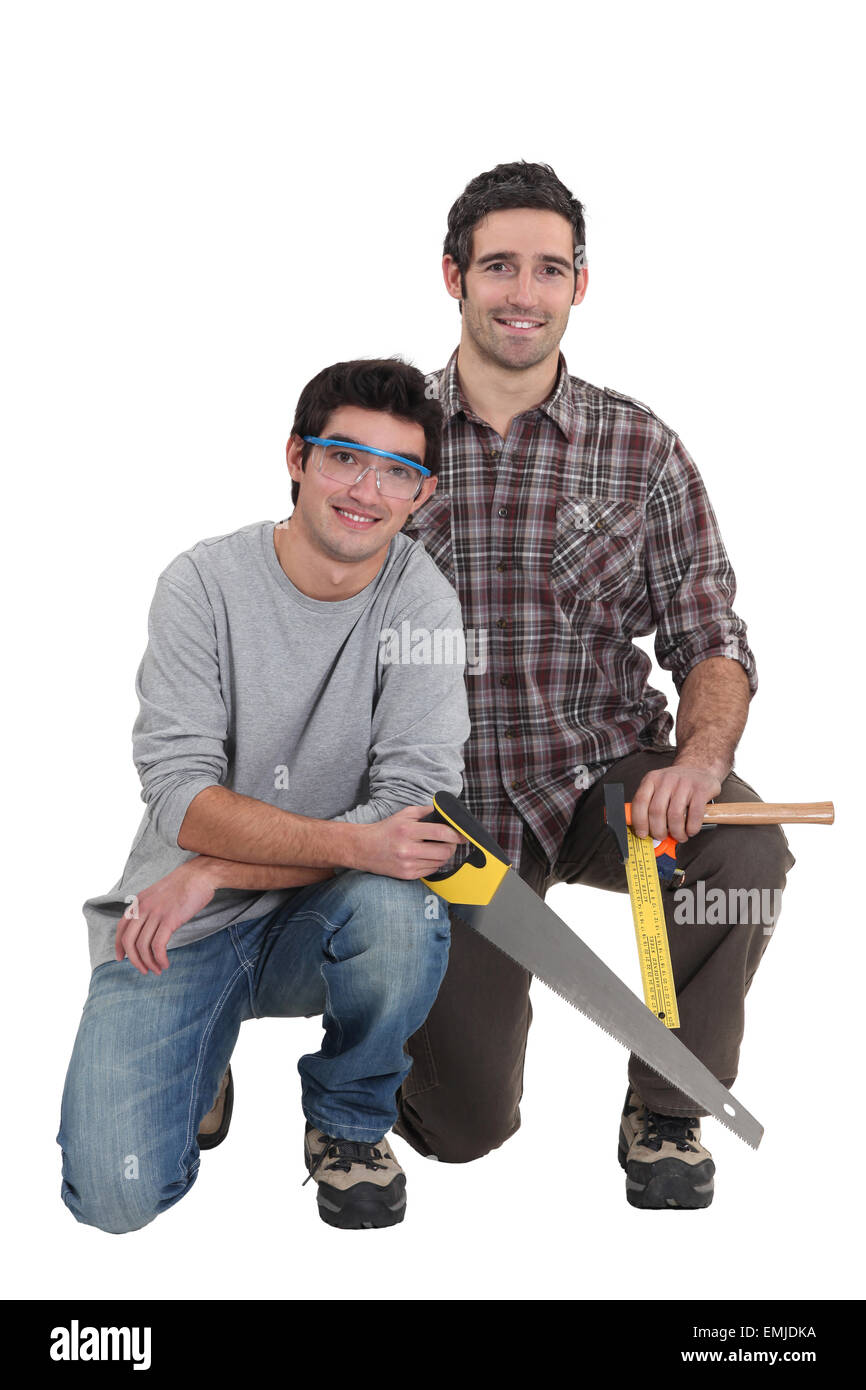 Carpenter and apprentice kneeling Stock Photo - Alamy