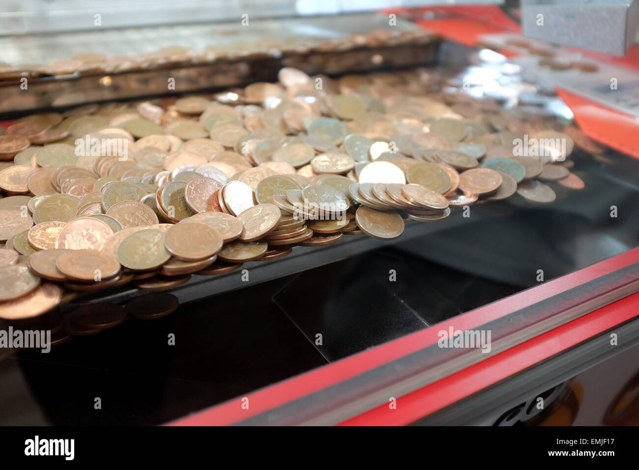 Two pence coins in a tipping point machine in a seaside arcade Stock ...