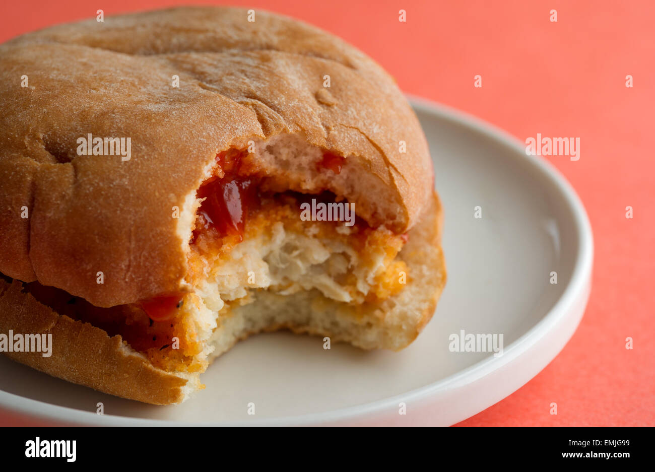 Close View Of A Freshly Cooked Breaded Chicken Sandwich With Ketchup That Has Been Bitten Once