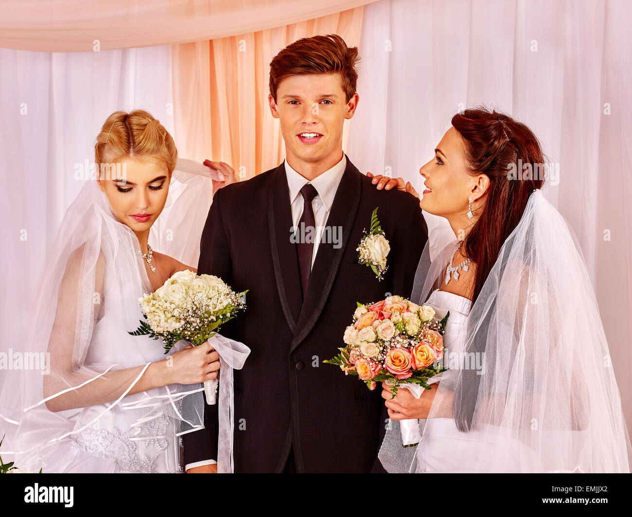 Happy wedding man and two bride Stock Photo - Alamy