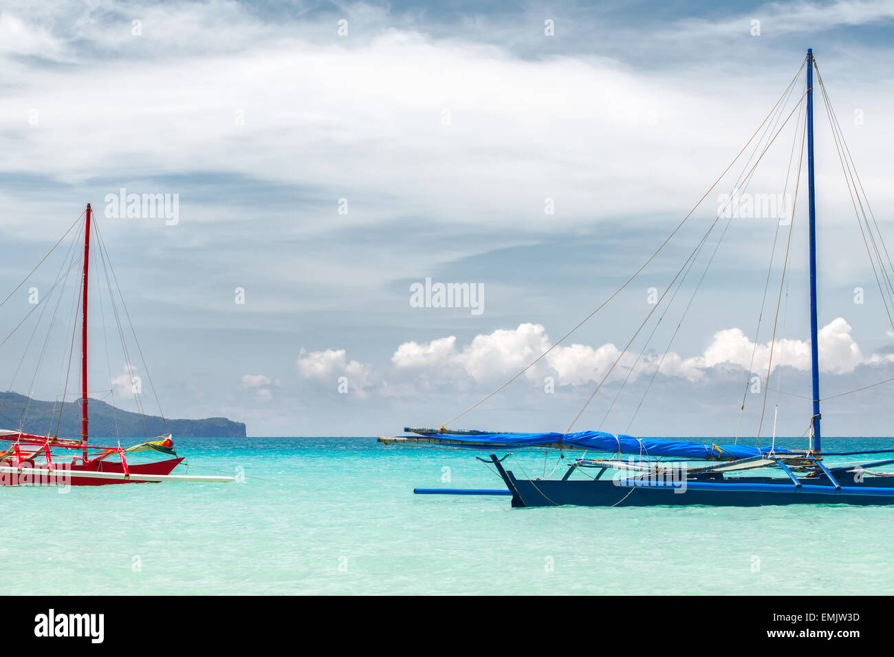 Red and blue motor boat on horizon of deep blue sea. Big white clouds ...