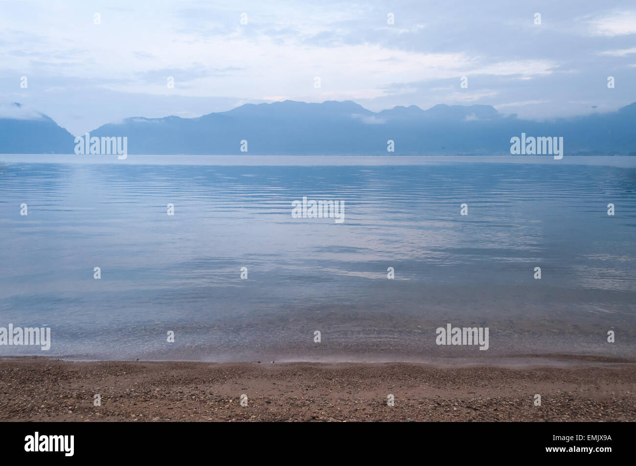 Lake Maninjau in the early morning. Lake Maninjau (Danau Maninjau) is a ...