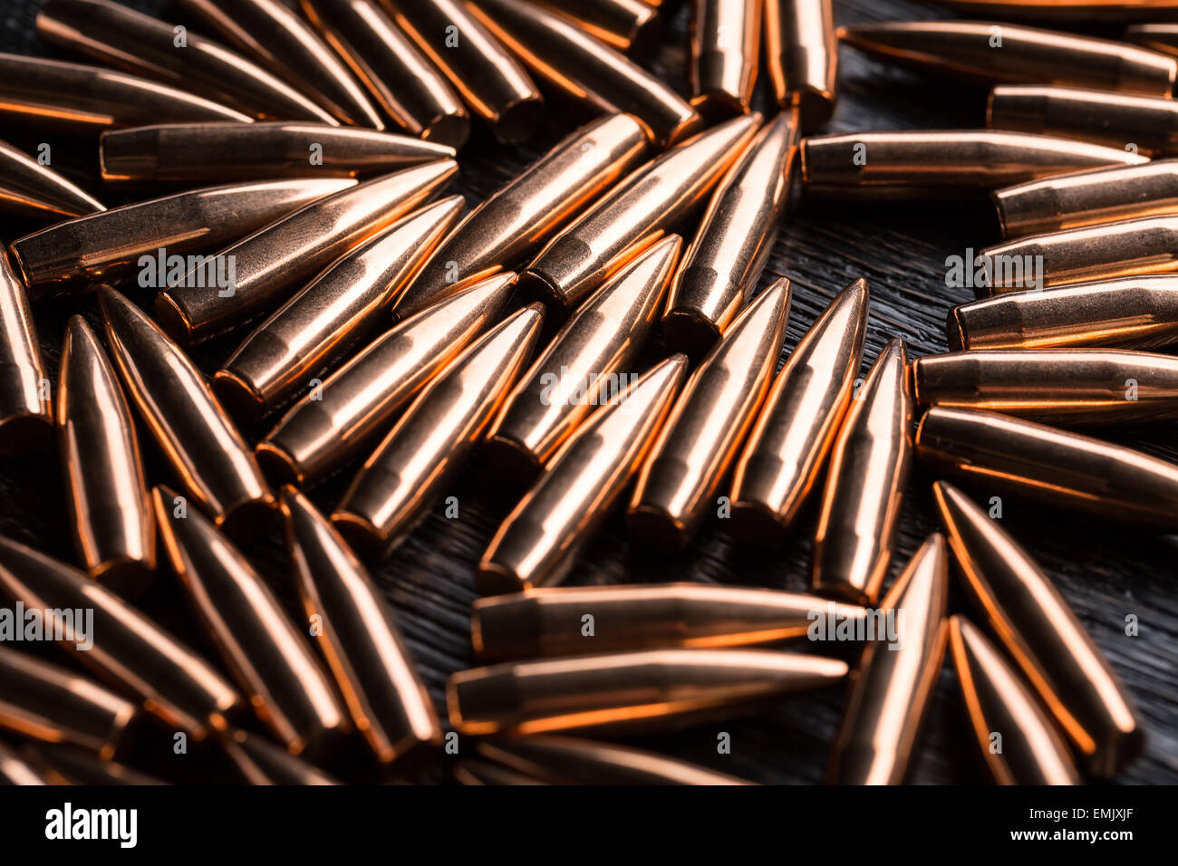 Placer copper bullets on a dark wooden background Stock Photo - Alamy