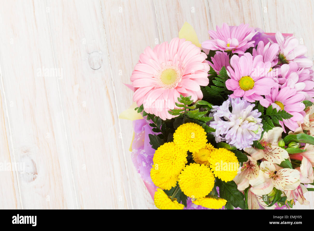 Colorful flowers bouquet on white wooden table. Top view with copy ...