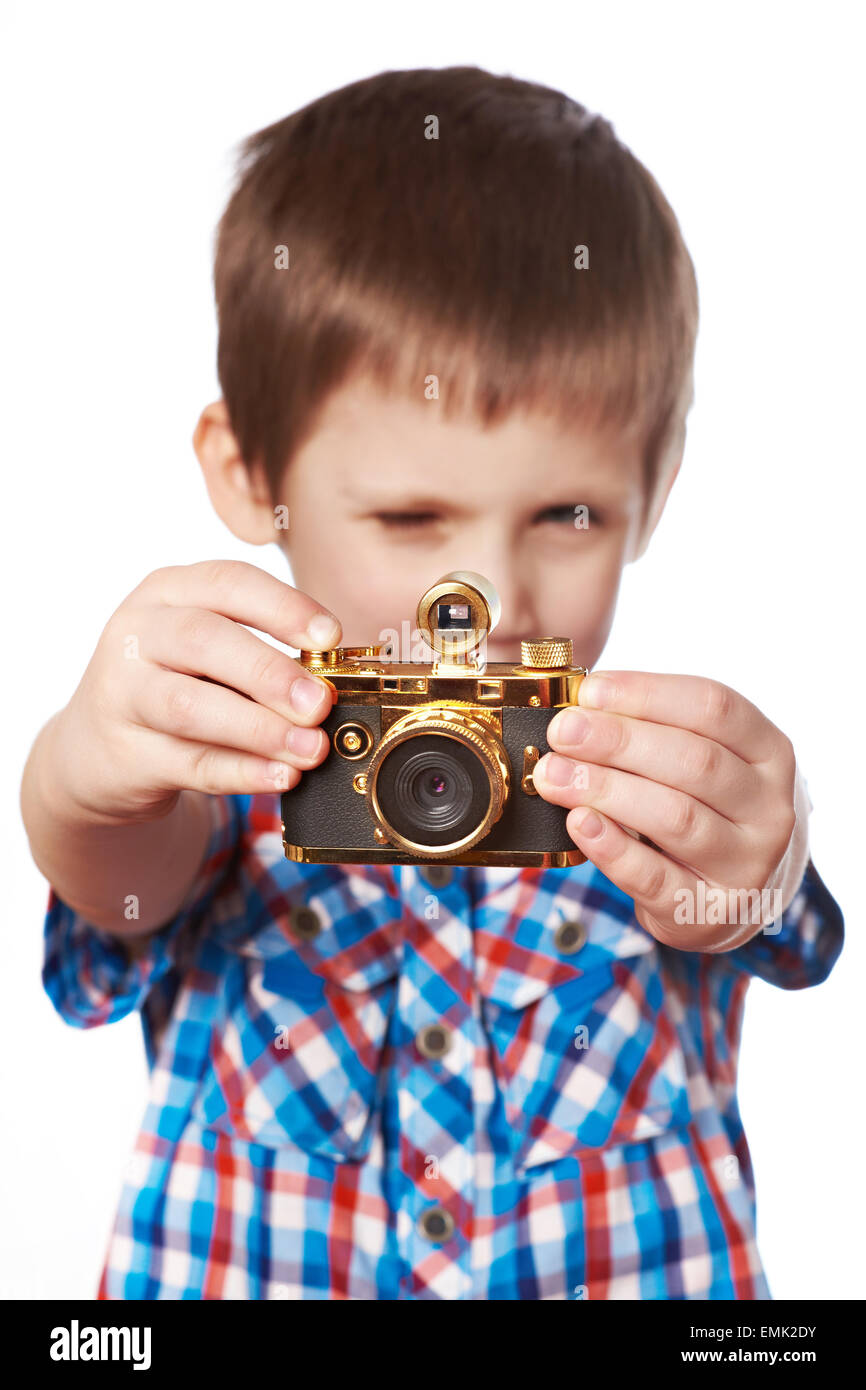 Little boy reporter photographer shooting with gold retro camera ...