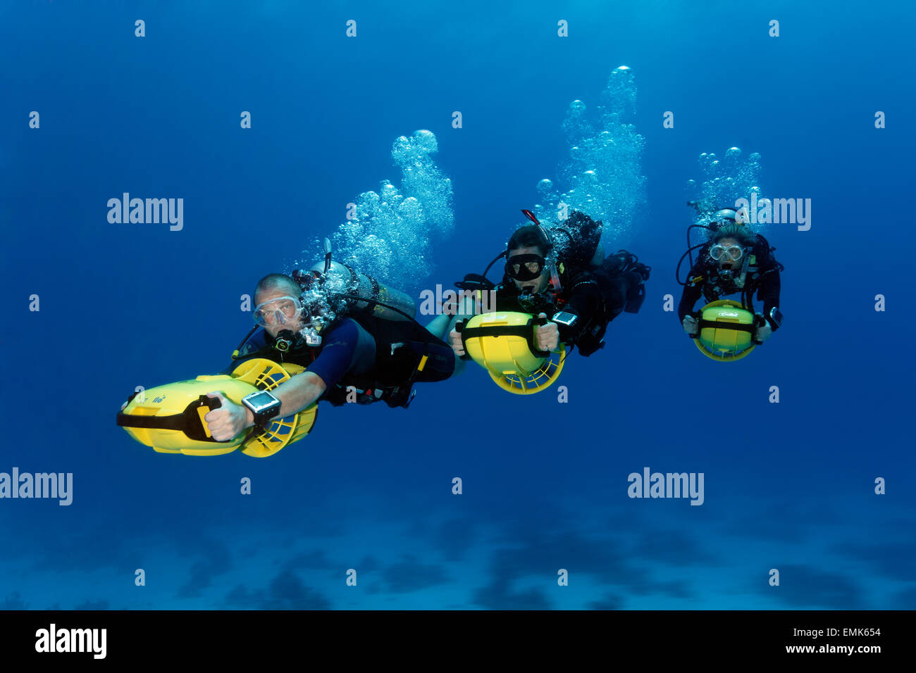 Divers with diver propulsion vehicles exploring a coral reef, Soma Bay ...