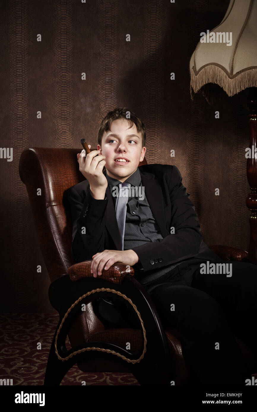 Young cigar smoker sitting in arm-chair, healthcare concept Stock Photo ...
